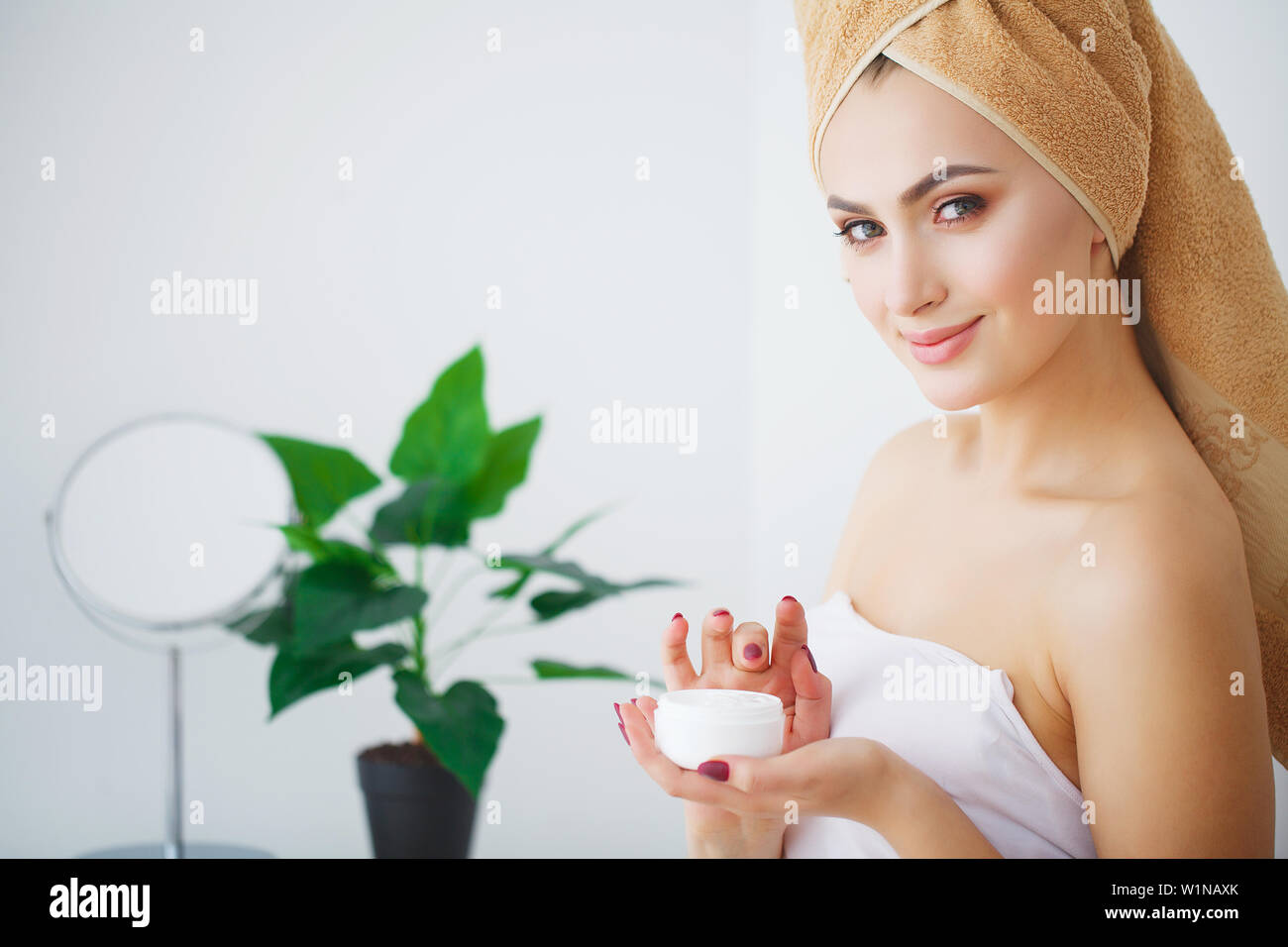 Spa. Beautiful model applying cosmetic cream treatmen on her face Stock ...