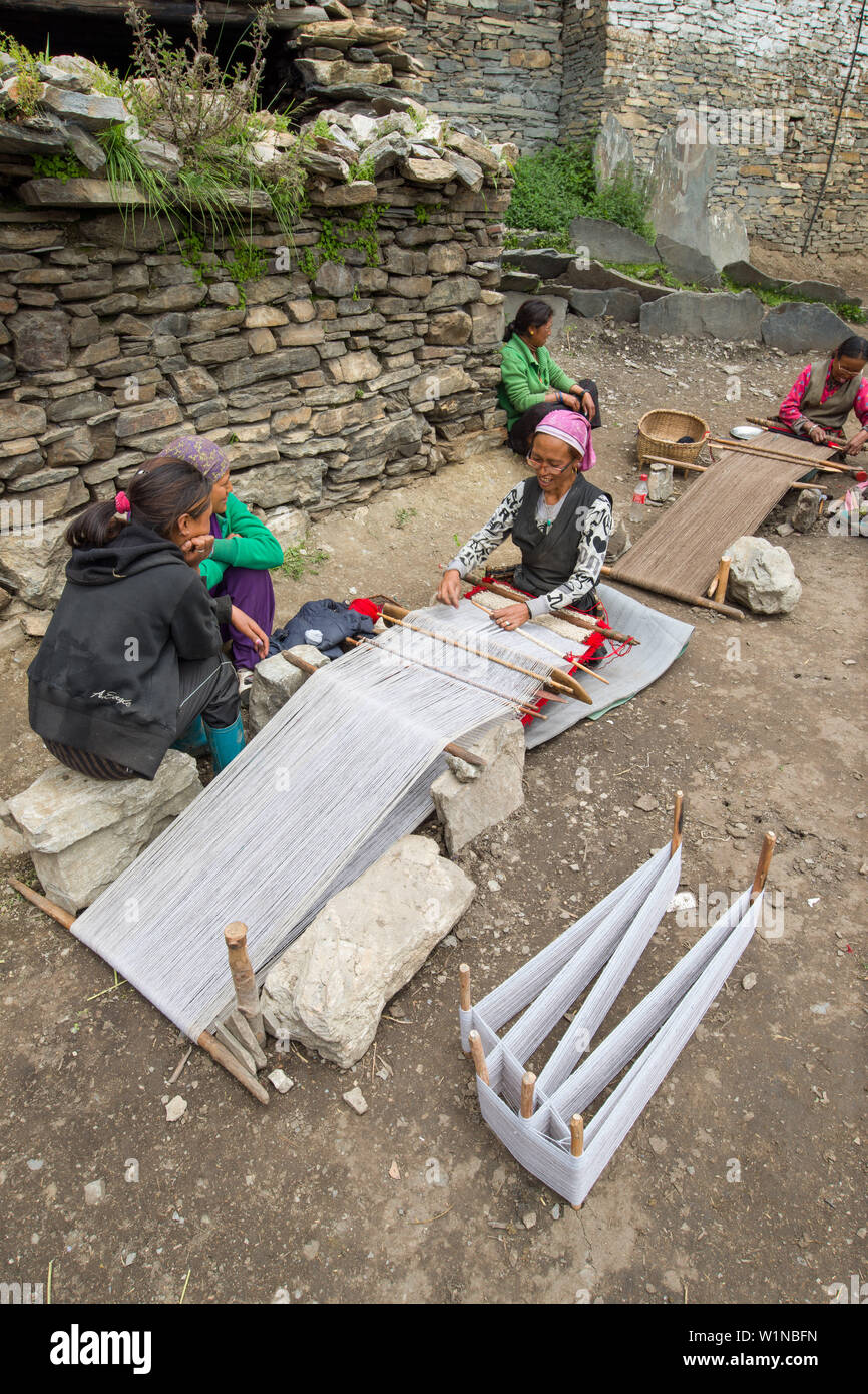 Women weaving on a simple weaving loom on the ground in Nar, Nepal ...
