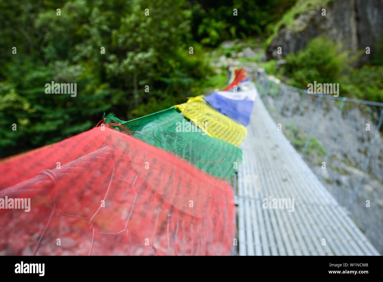 Prayer flags at a suspension bridge on the Nar Phu Trek, Nepal ...