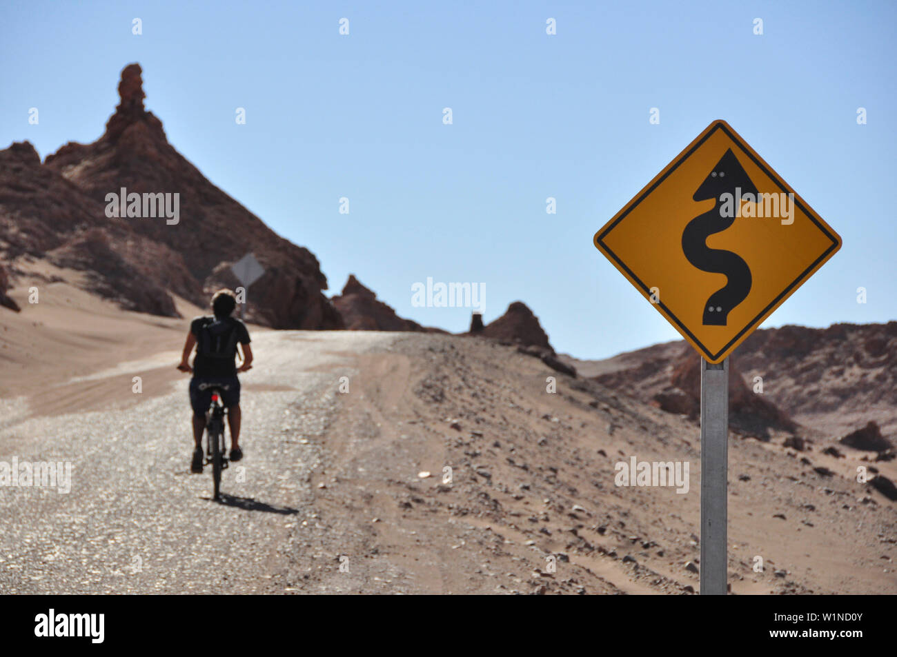 Man cycling and crossing traffic sign at road, Valle de la Luna, Valley ...