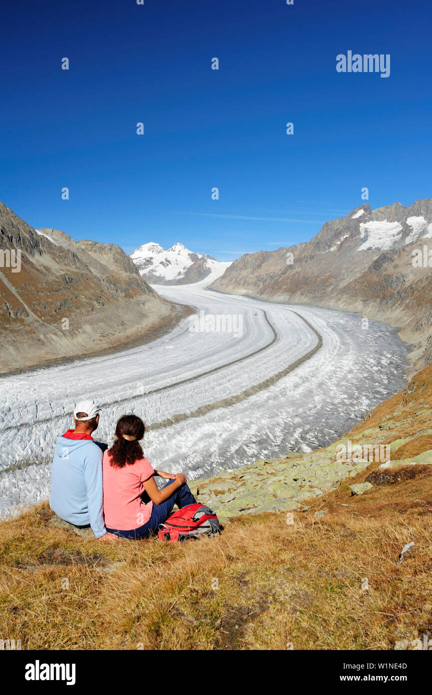 Couple looking towards glacier Grosser Aletschgletscher with Moench and ...