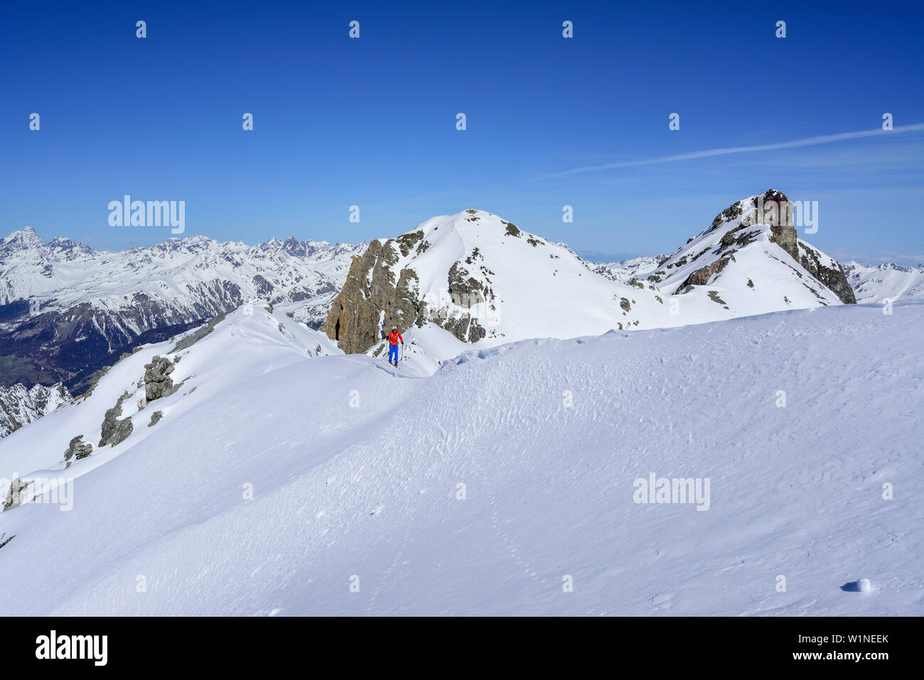 Woman back-country skiing ascending on ridge towards Piz Lischana, Piz ...