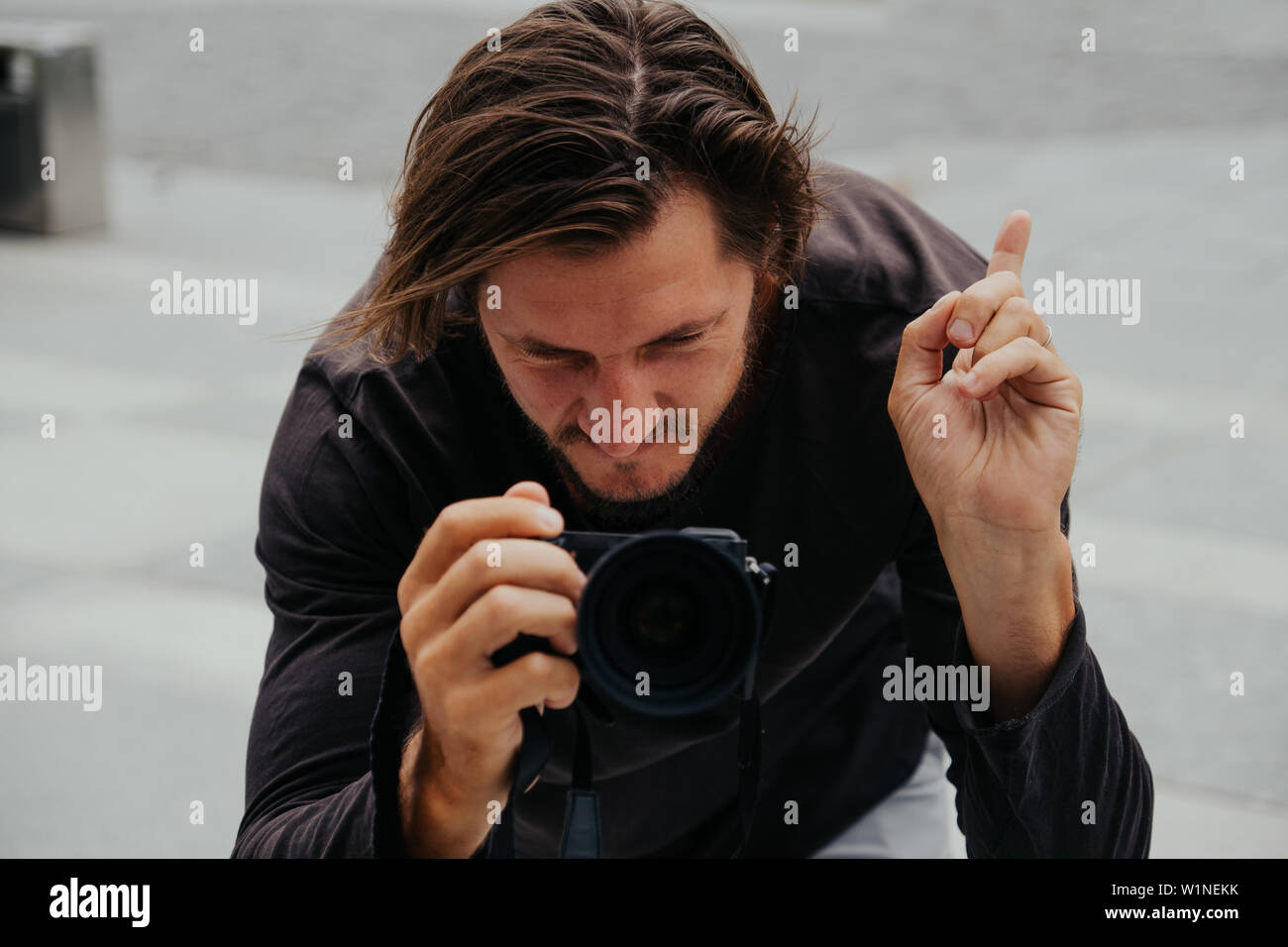 Stylish hipster photographer in a big city with a camera and a backpack ...