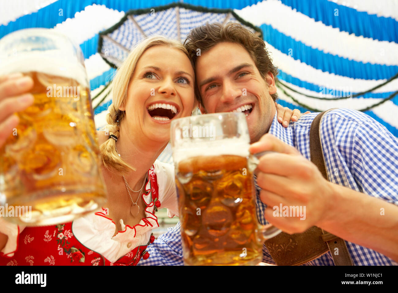 Couple clinking beer glasses in a beer tent Stock Photo - Alamy