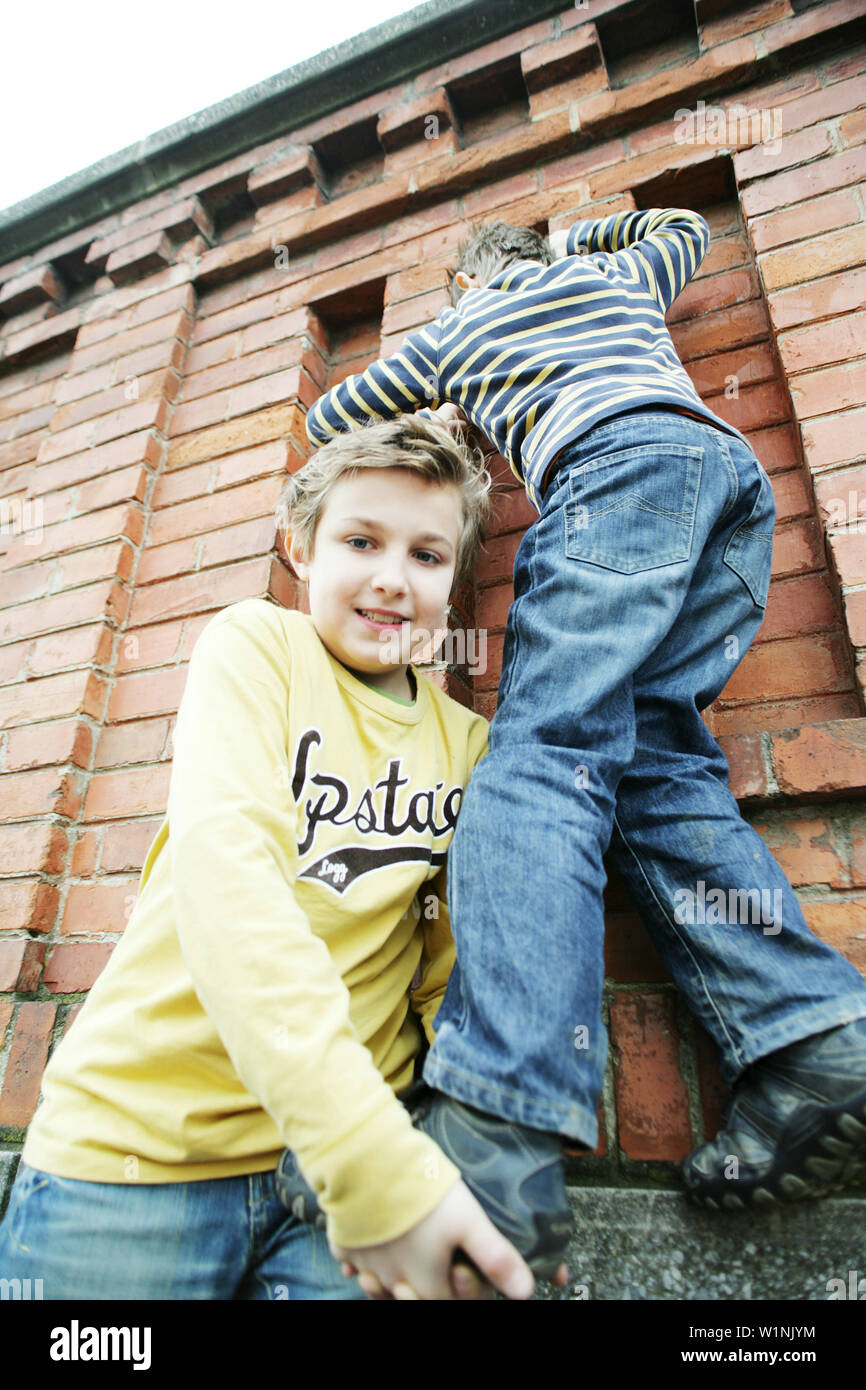Boy climbing over wall hi-res stock photography and images - Alamy