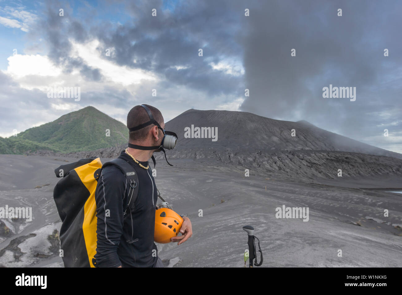 Eruption of the active Tavurvur volcano and ash cloud. Man with gas ...