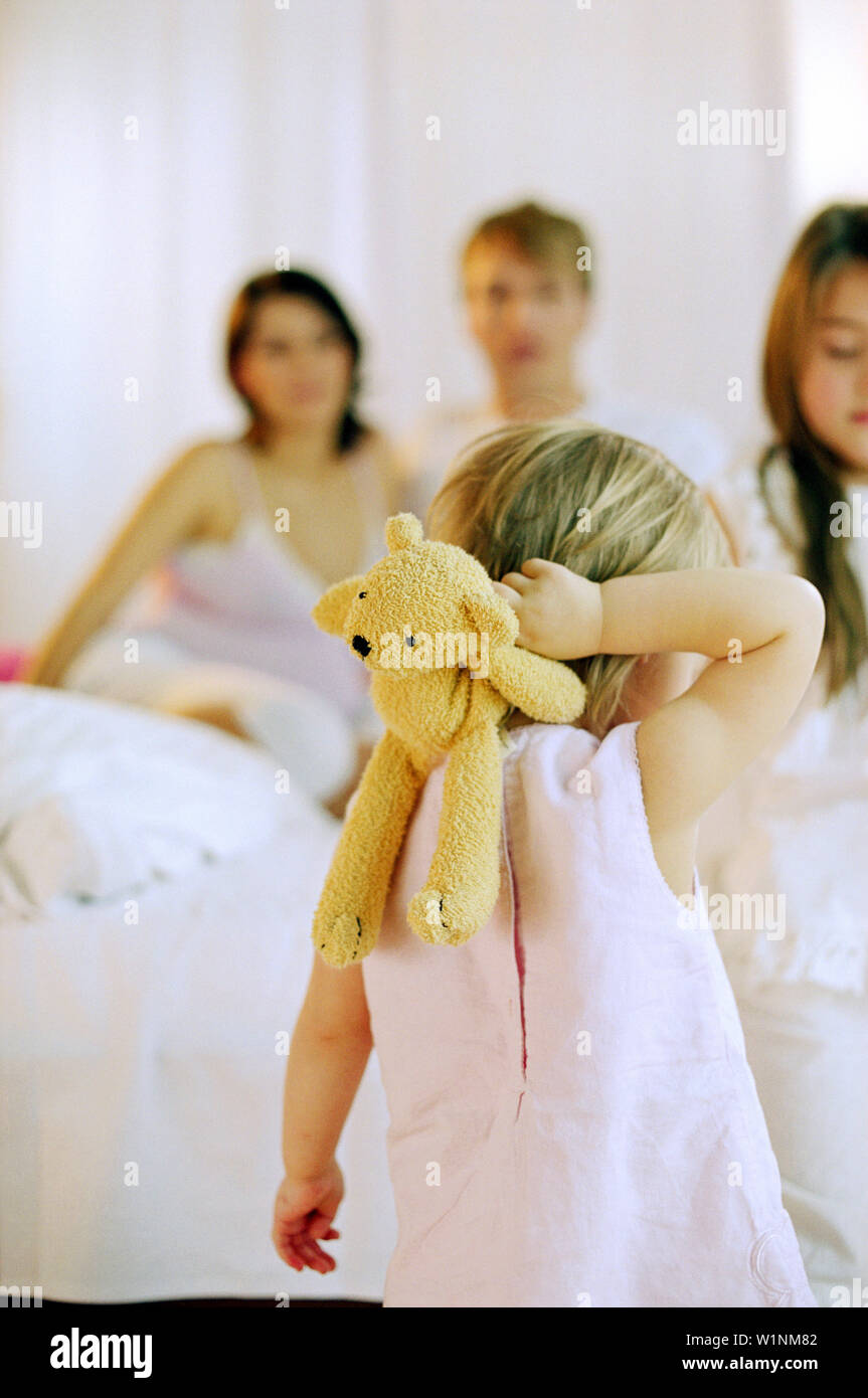 Toddler girl holding her teddy, rear view Stock Photo - Alamy
