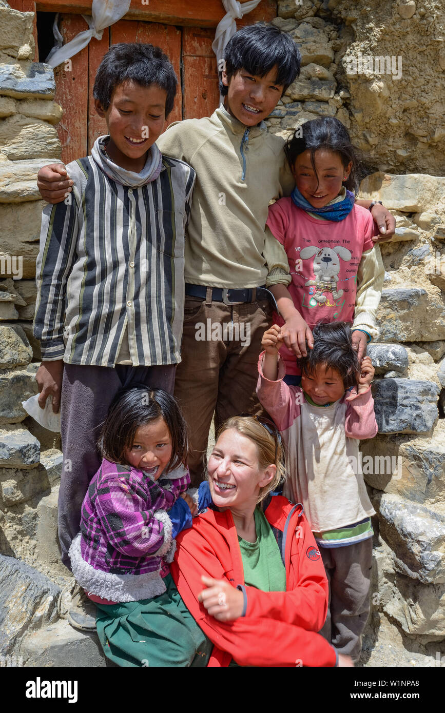 Young women, trekker, hiker with local children at Luri Gompa, Luri ...