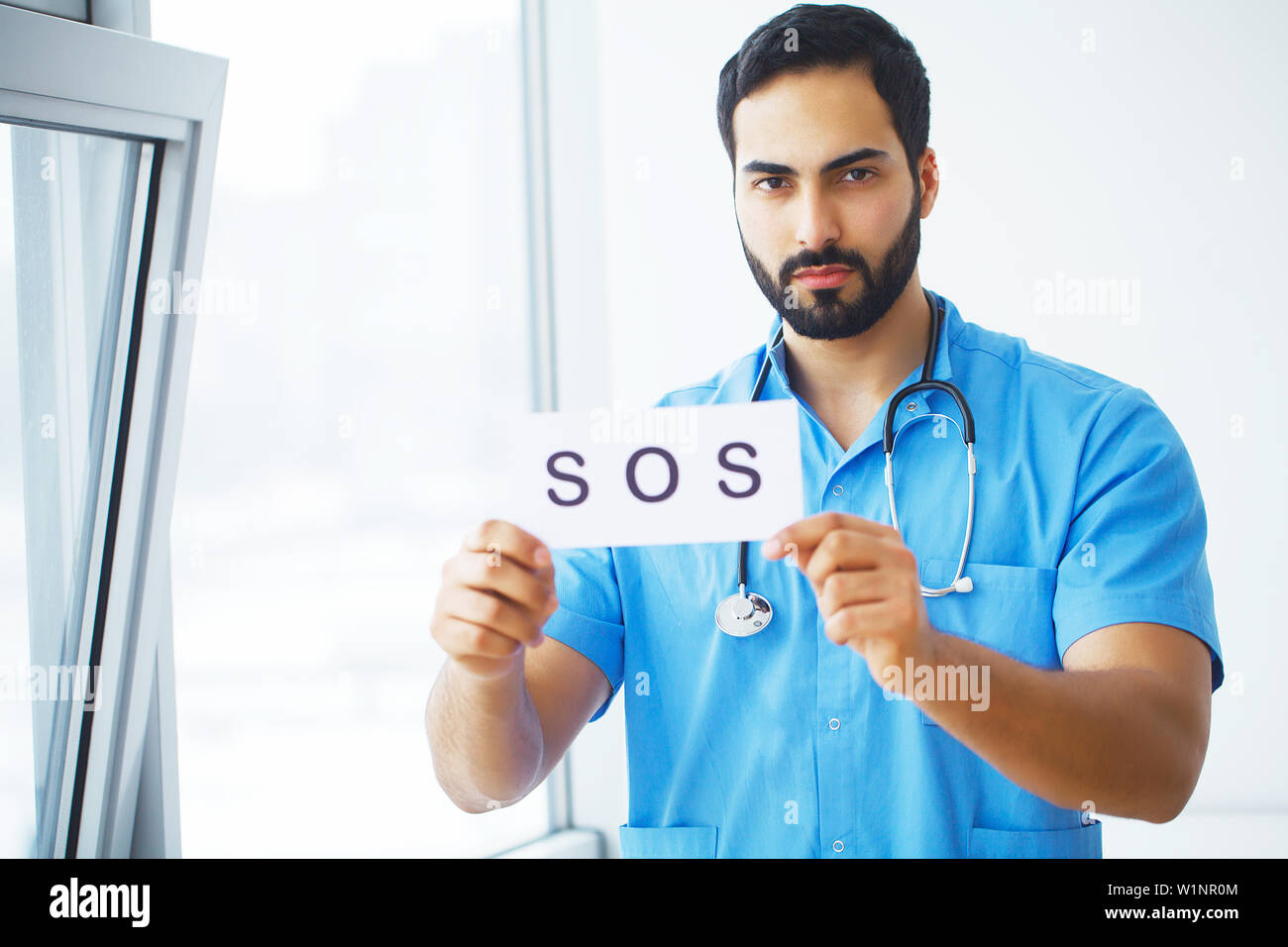 Doctor holding a card with symbol Sos, Medical concept Stock Photo - Alamy