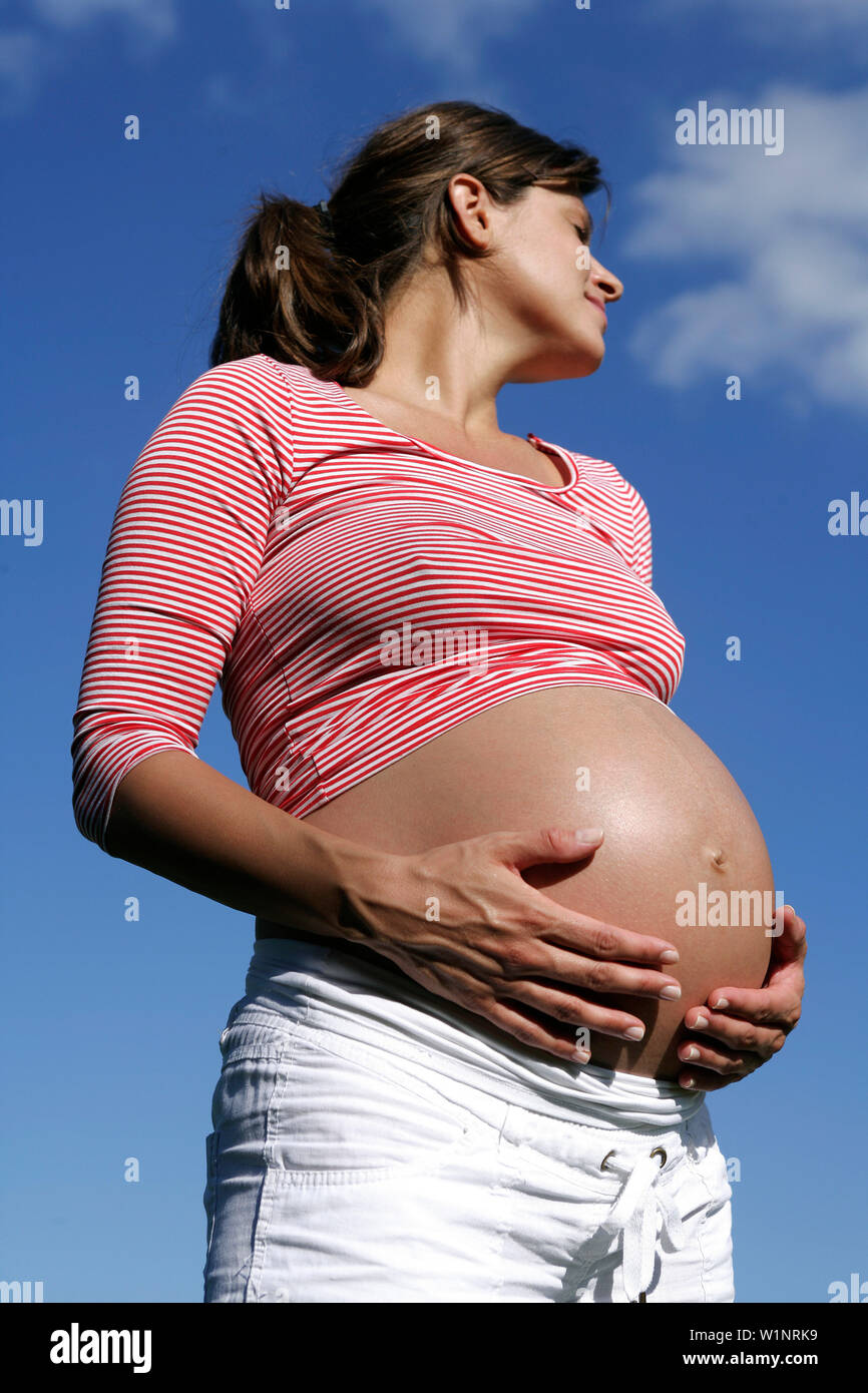 Pregnant woman touching belly Stock Photo - Alamy