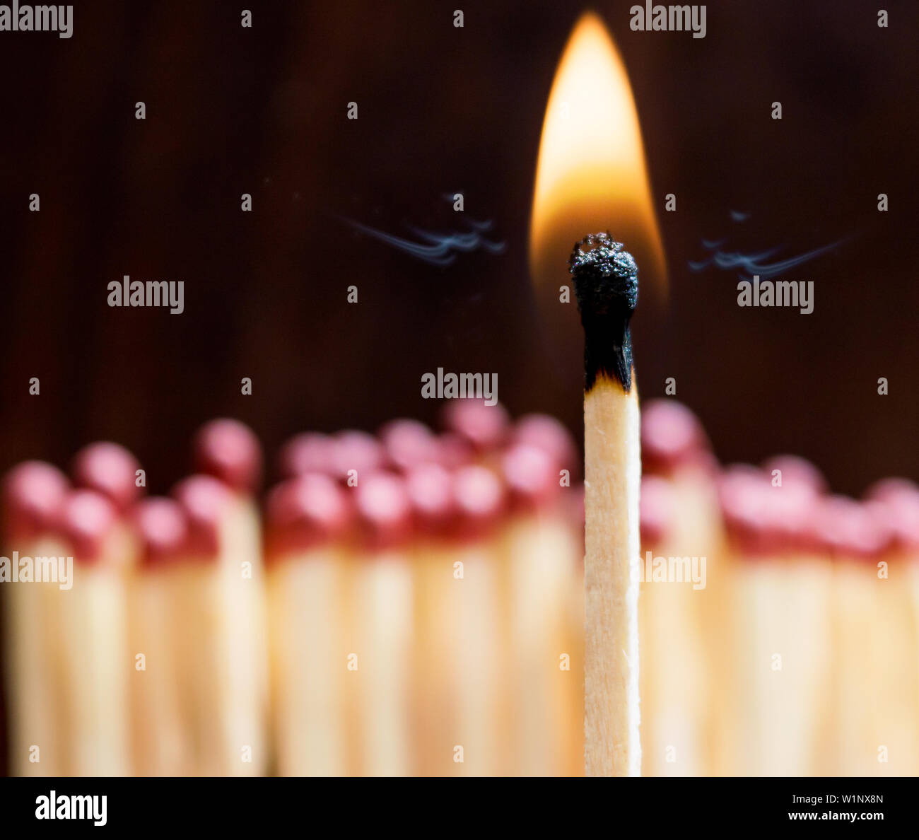 Many matches on a black background ,one match burns Stock Photo - Alamy