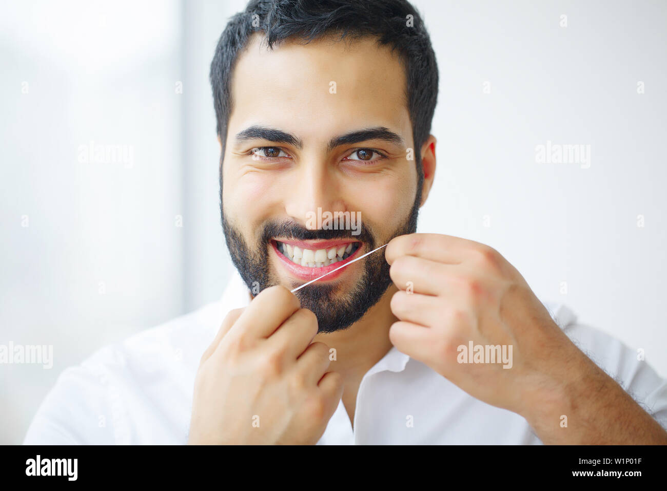 Dental Health. Man With Beautiful Smile Flossing Healthy Teeth. High ...