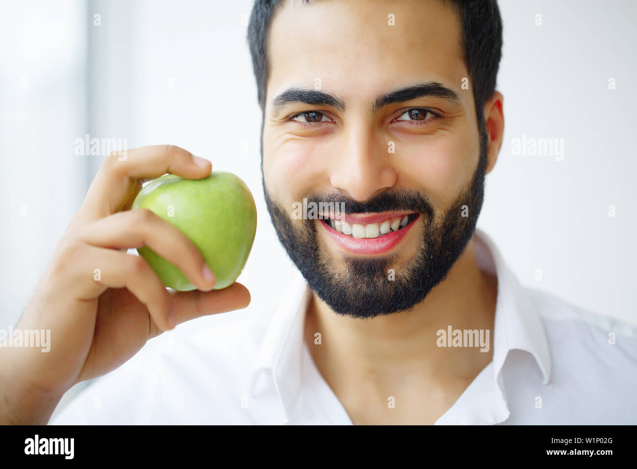Man Eating Apple. Beautiful Girl With White Teeth Biting Apple. High ...