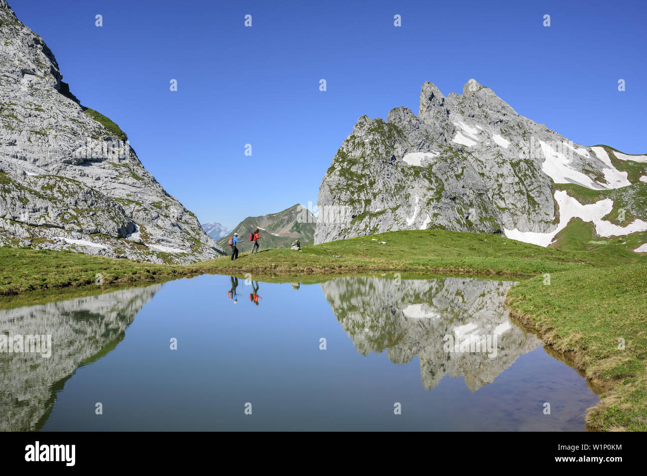 Two persons hiking at mountain lake, Schweizer Tor, Raetikon trail ...