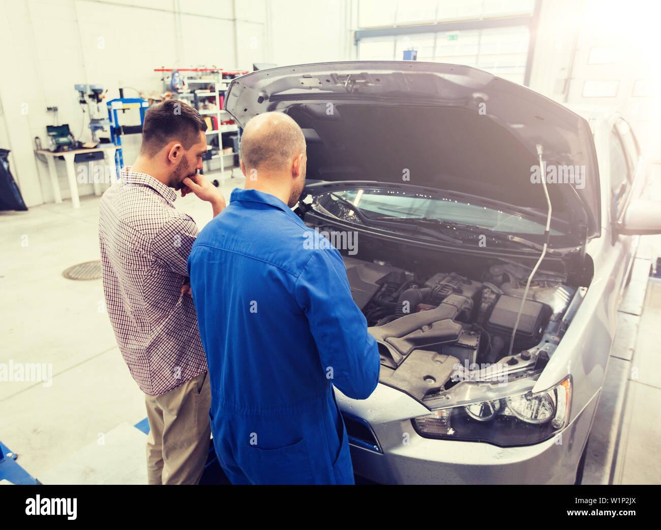 auto mechanic and man or car owner at workshop Stock Photo - Alamy