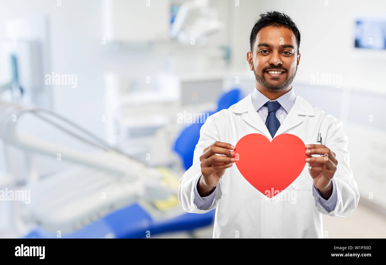 male dentist with red heart at dental clinic Stock Photo - Alamy