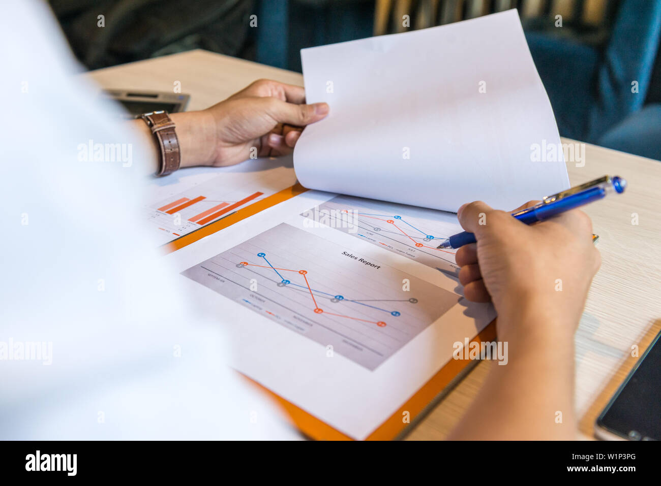 Close up of hand holding pen pointing graph sales report Stock Photo ...