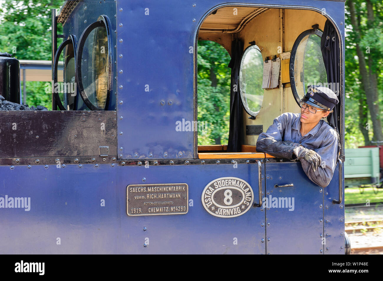 Railway station with historical steam railway. Locomotive driver looks ...