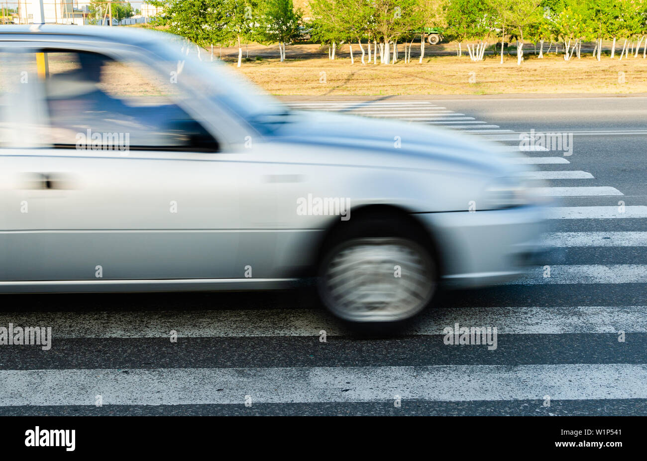 Car at high speed passes through a pedestrian Zebra Stock Photo - Alamy