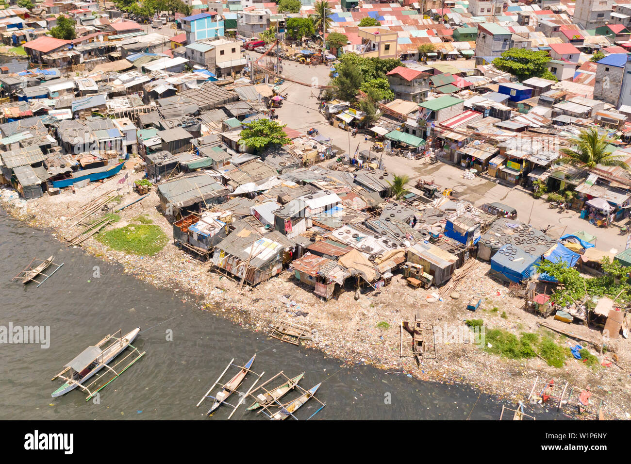 Slums in Manila, a top view. Houses of poor people and boats in poor ...