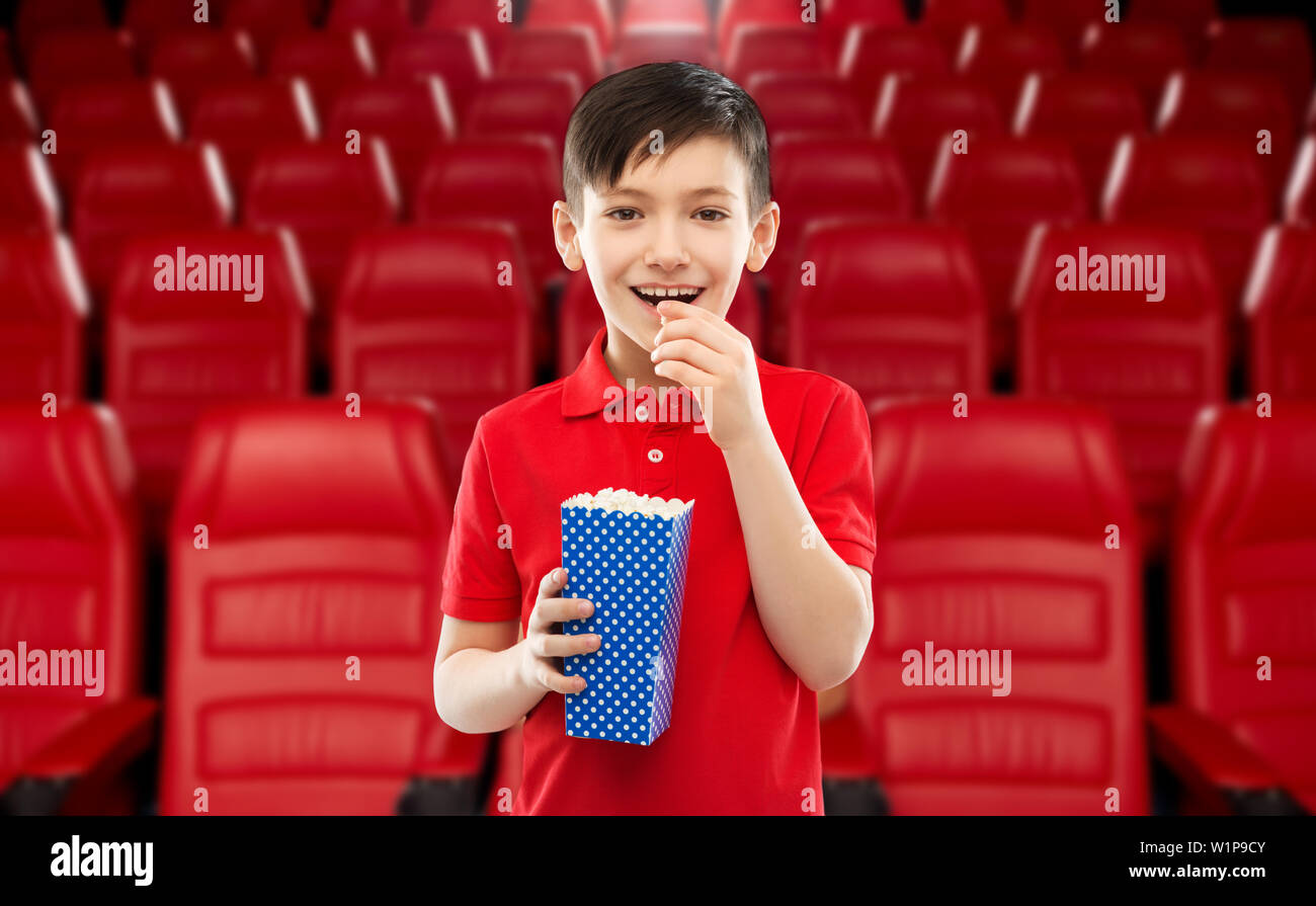 smiling boy eating popcorn at movie theater Stock Photo - Alamy