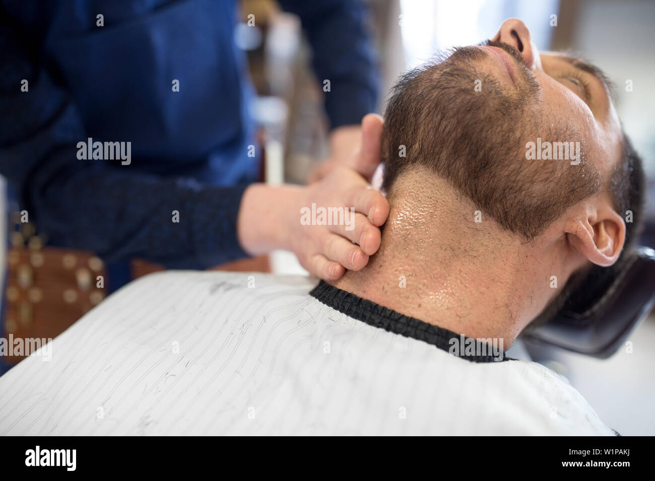 barber treating male client's neck at barbershop Stock Photo - Alamy