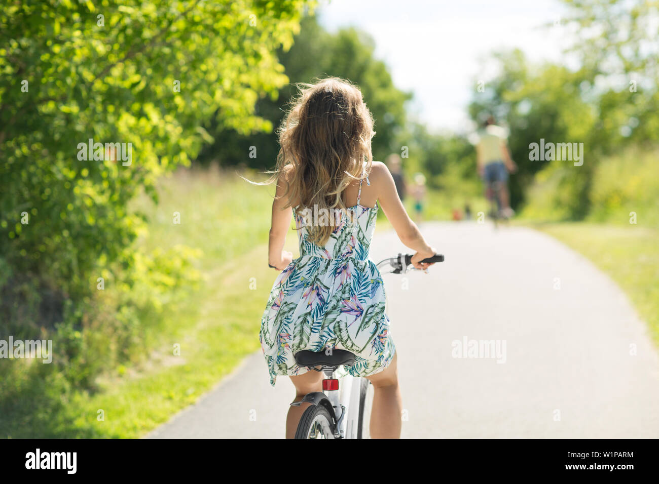 Back view girl riding bicycle hi-res stock photography and images - Alamy