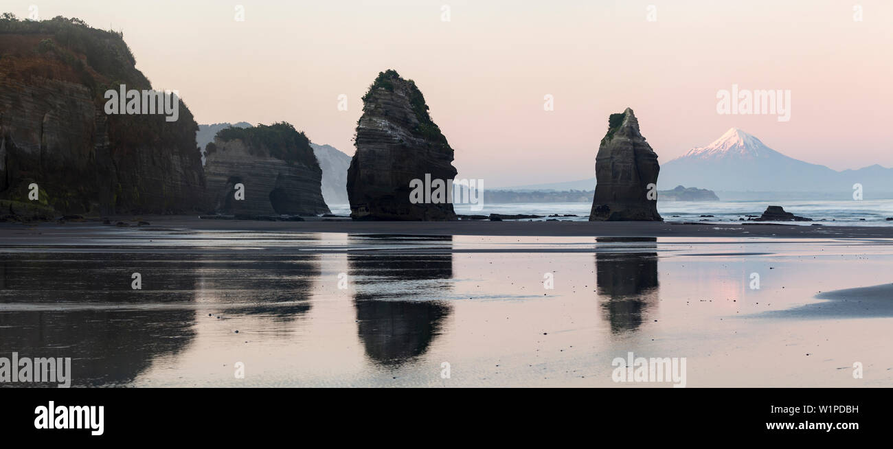 Rock formations and view of Mount Taranaki volcano, Tongaporutu ...