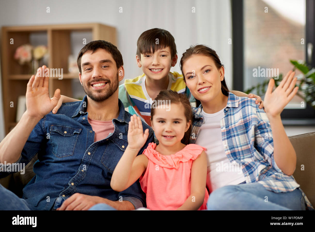 portrait of happy family waving hands at home Stock Photo - Alamy