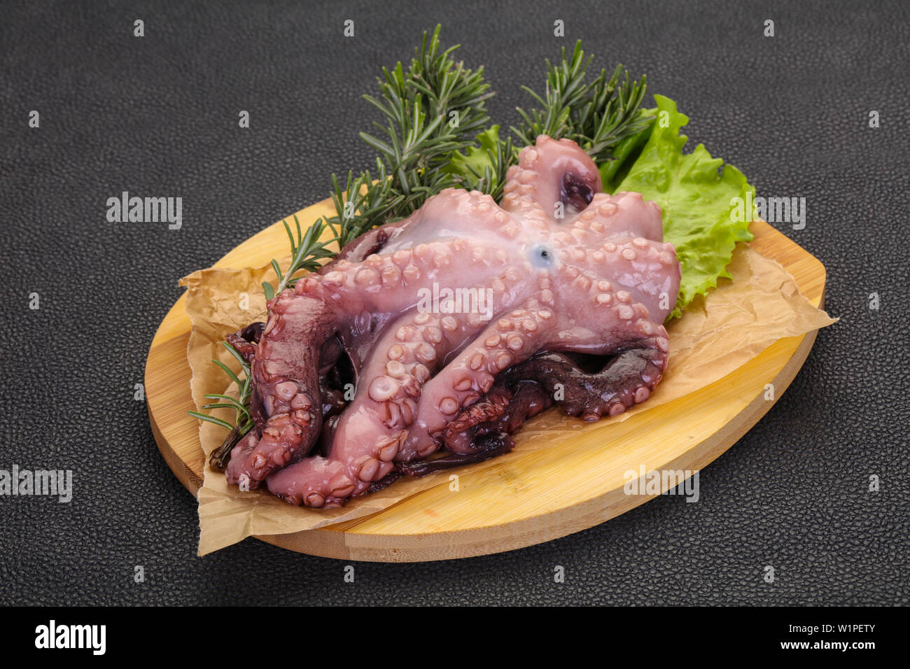 Raw octopus ready for cooking with rosemary Stock Photo - Alamy