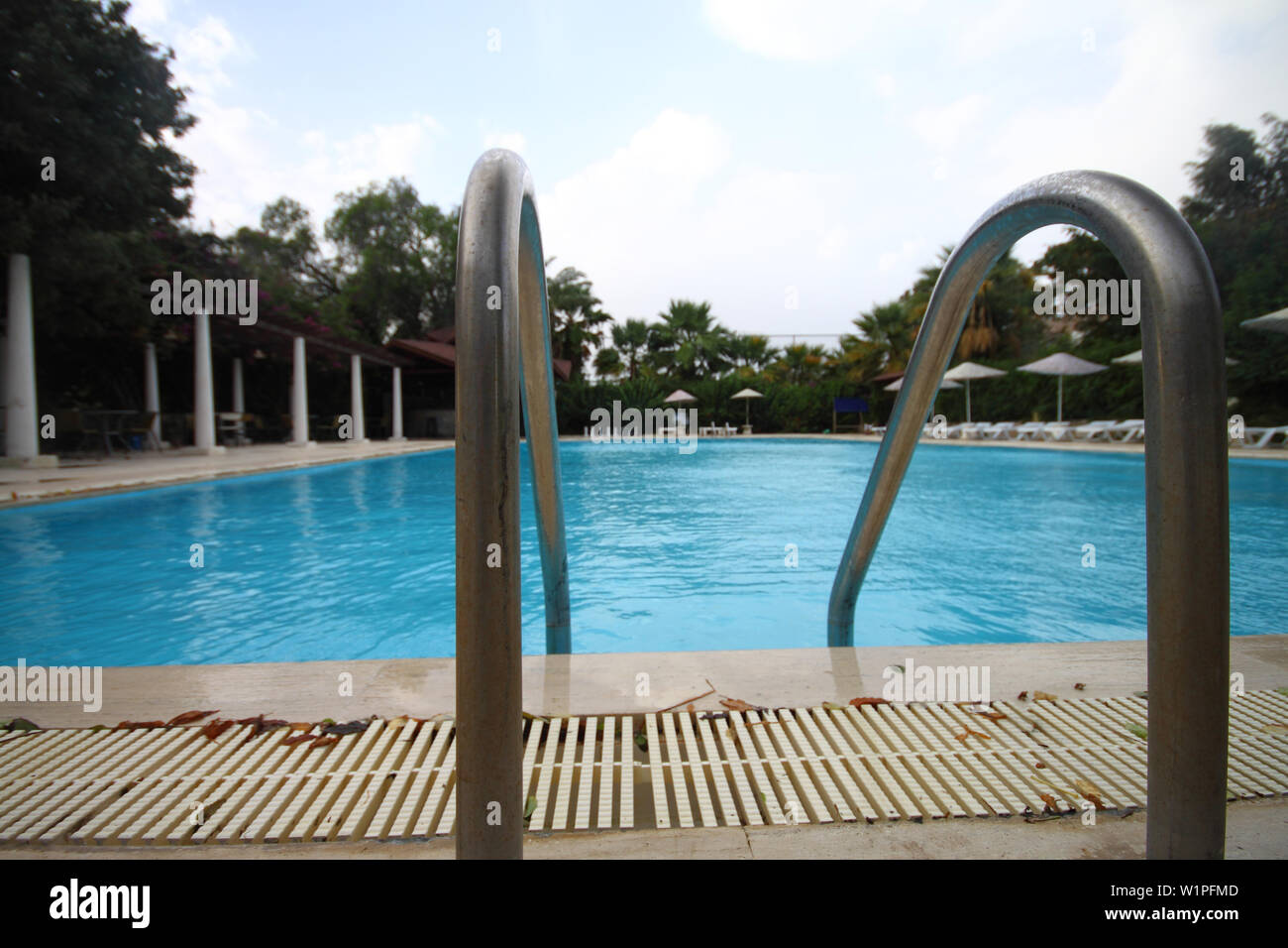 Outside swimming pool metal staircase into the water. Comfortable pool ...