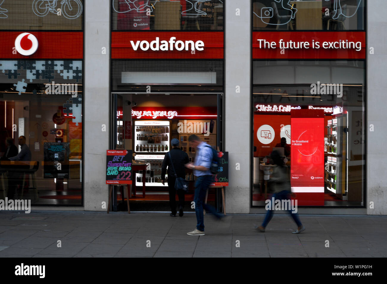 London, Britain. 3rd July, 2019. People walk past a Vodafone store in ...