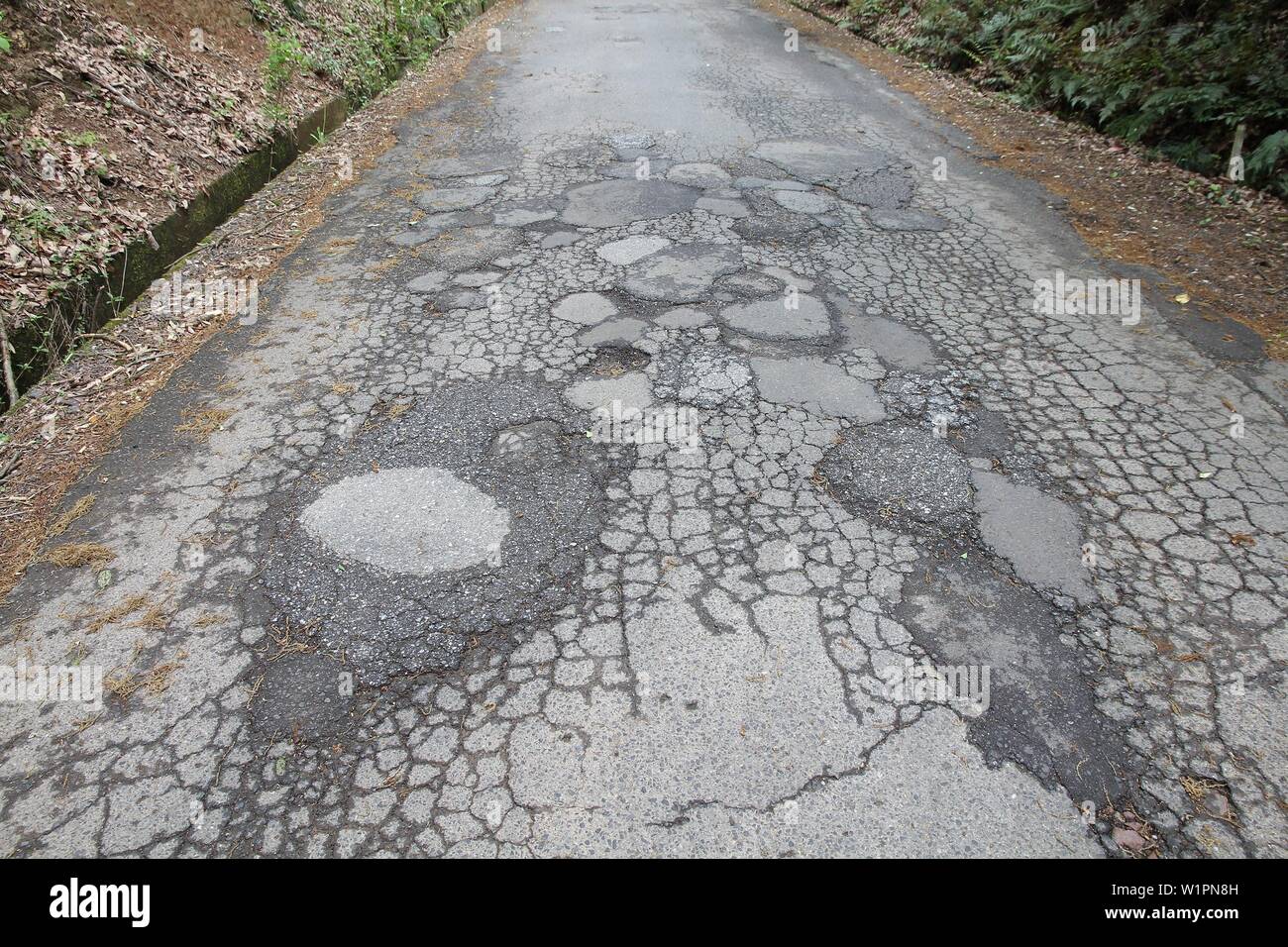 Road damage in Japan - cracked asphalt blacktop with potholes and ...