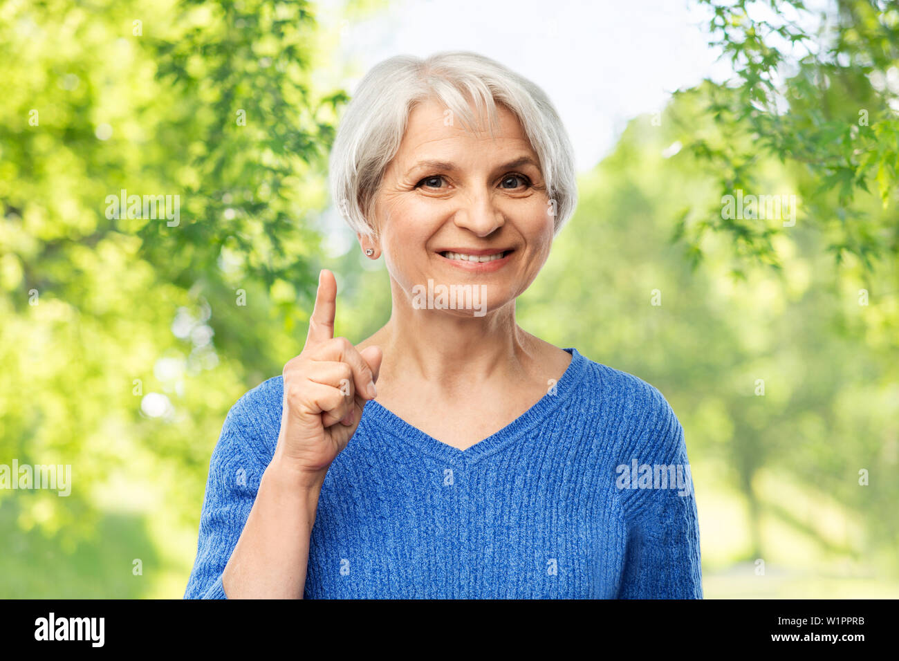 Woman mature pointing up hi-res stock photography and images - Alamy