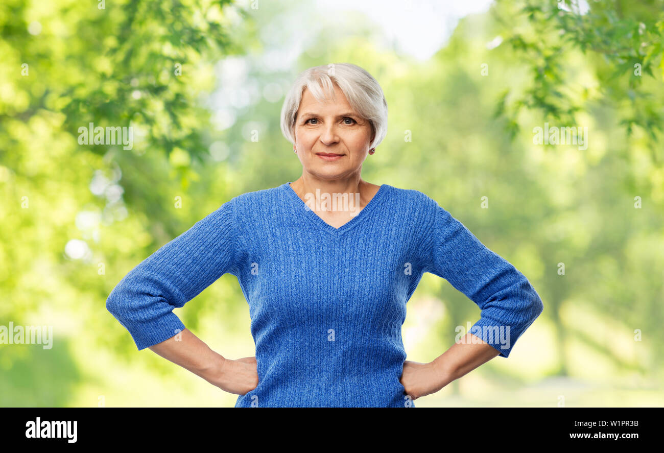 senior woman in blue sweater hands on hips Stock Photo - Alamy