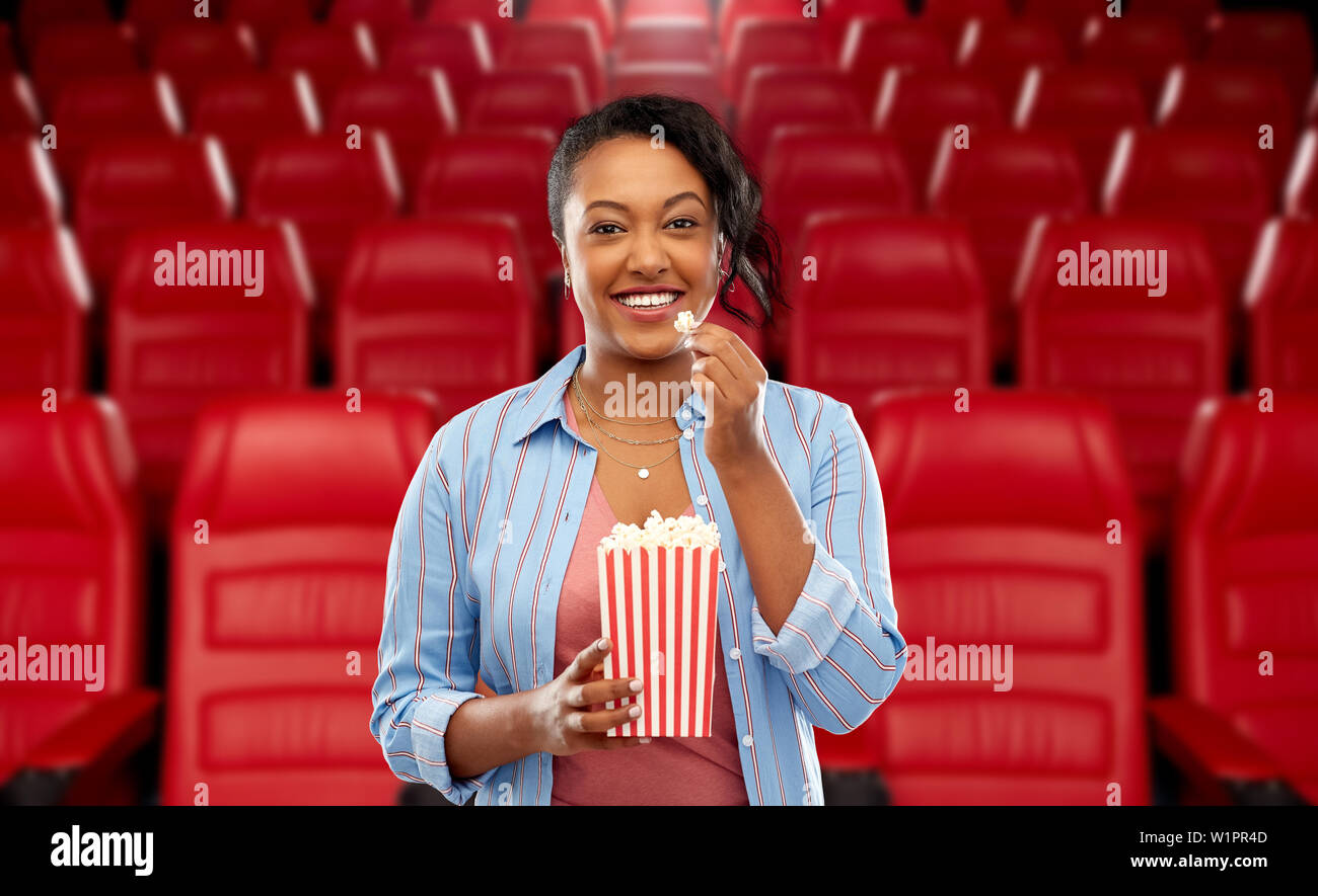 african woman eating popcorn at movie theater Stock Photo - Alamy