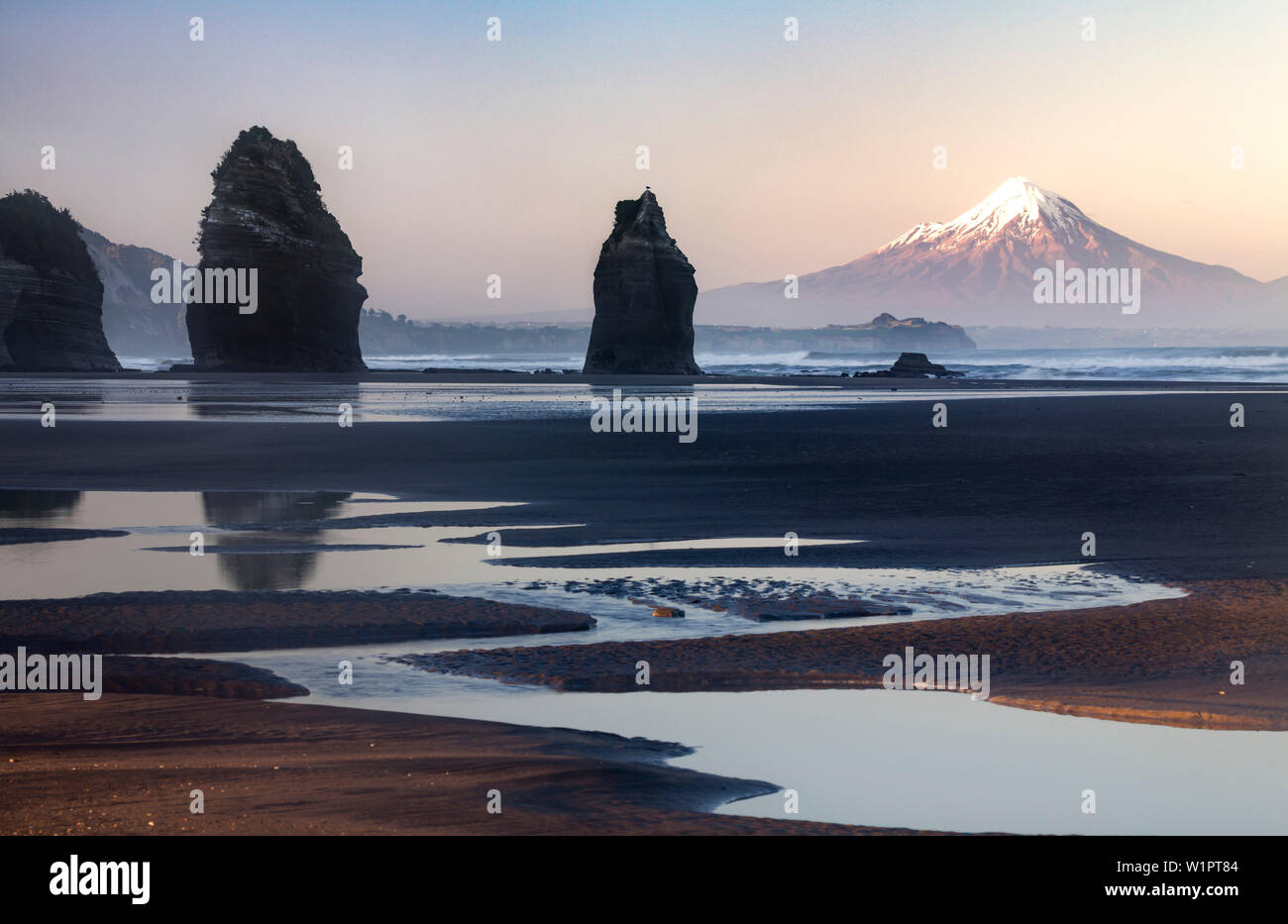 Rock formations and view of Mount Taranaki volcano, Tongaporutu ...