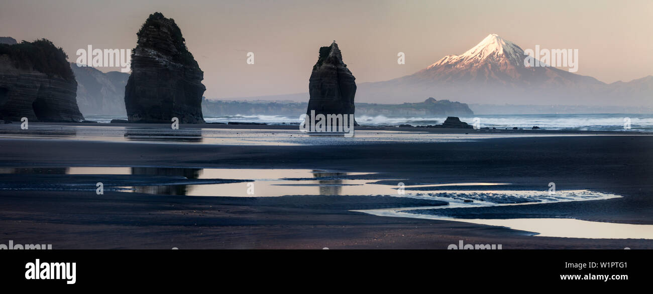 Rock formations and view of Mount Taranaki volcano, Tongaporutu ...