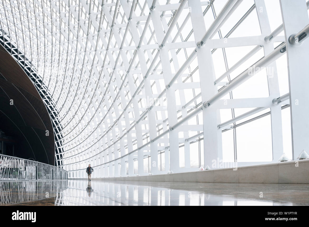 man walking along window corridor, interior architeture of National ...