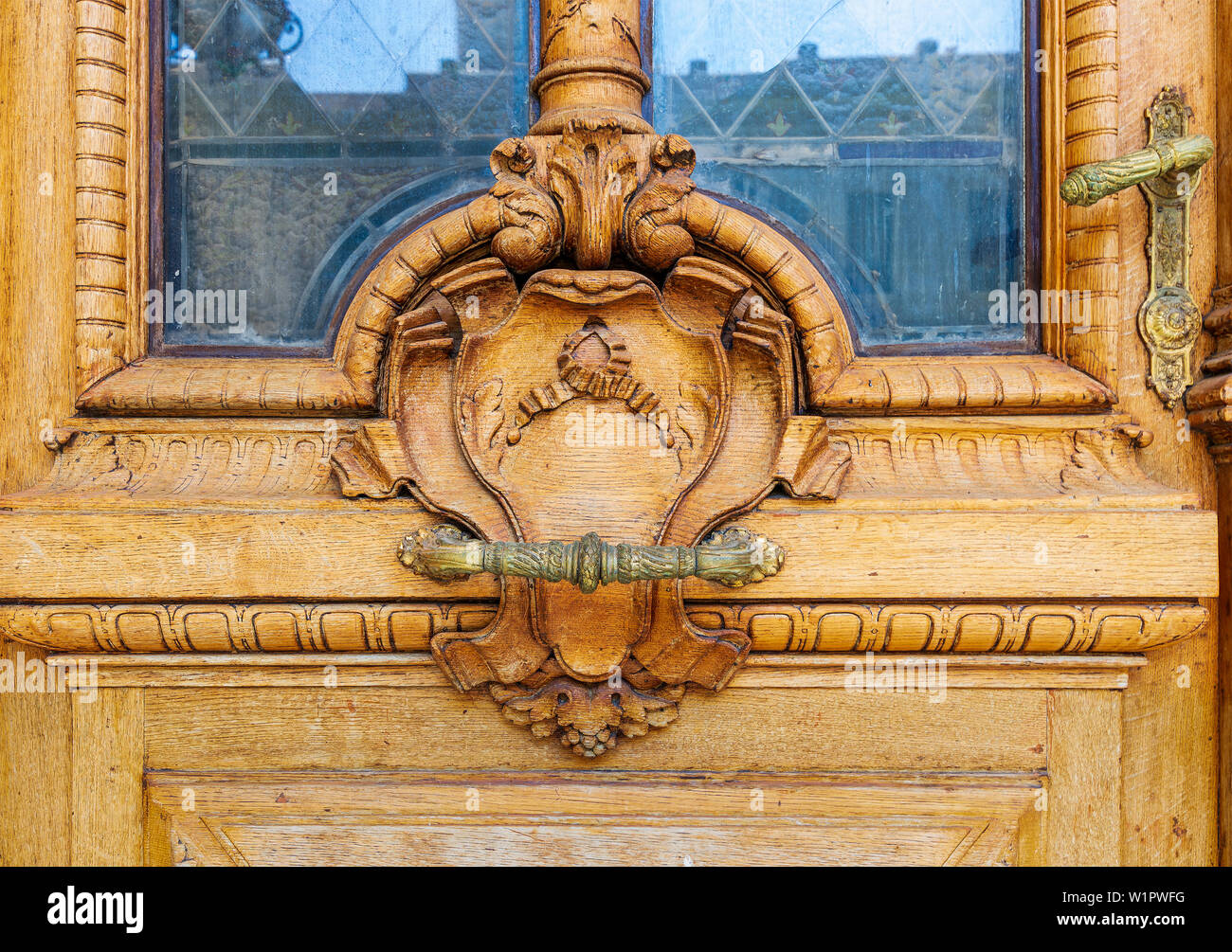 Closeup of wooden floral pattern engravings and handlebar on old door ...