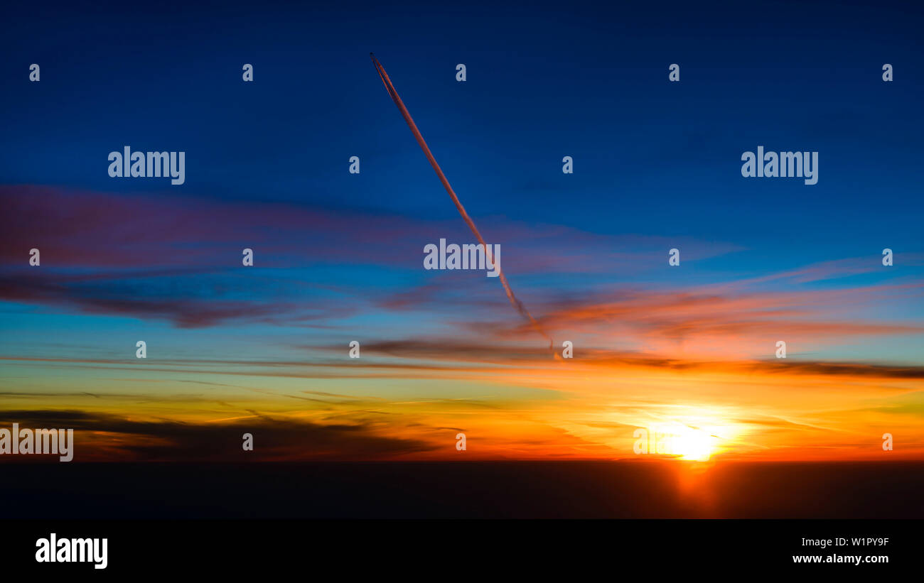 contrail of an airplane in a higher flightlevel gets illuminated in ...