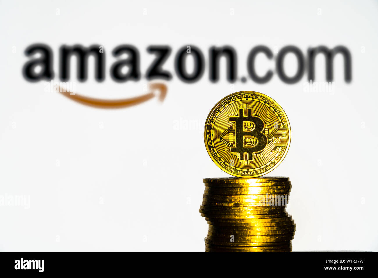 Gold Bitcoin coins with the Amazon logo on background screen. A new ...