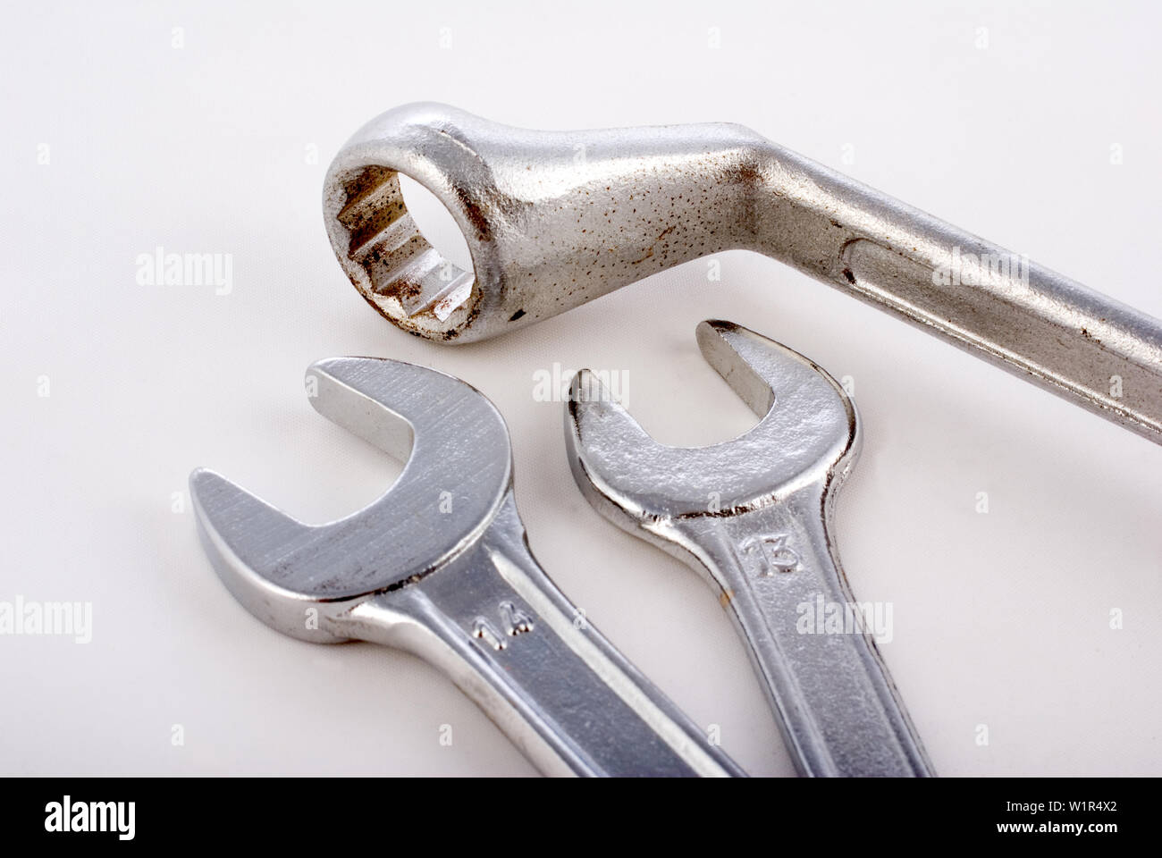 three shiny metal wrenches tools on white background Stock Photo - Alamy