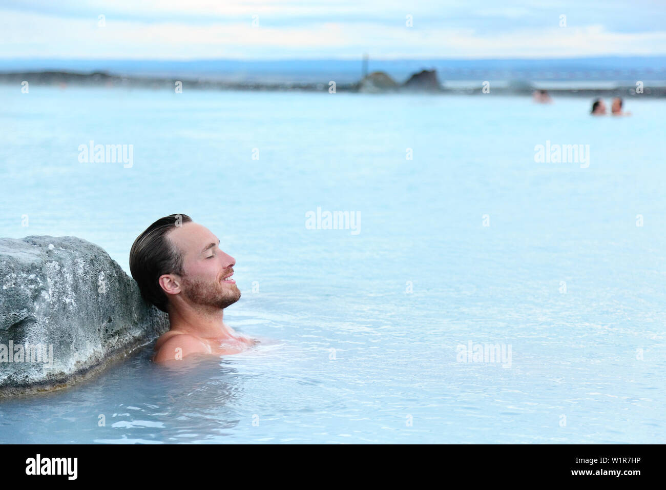 Geothermal spa. Man relaxing in hot spring pool on Iceland. Young man ...