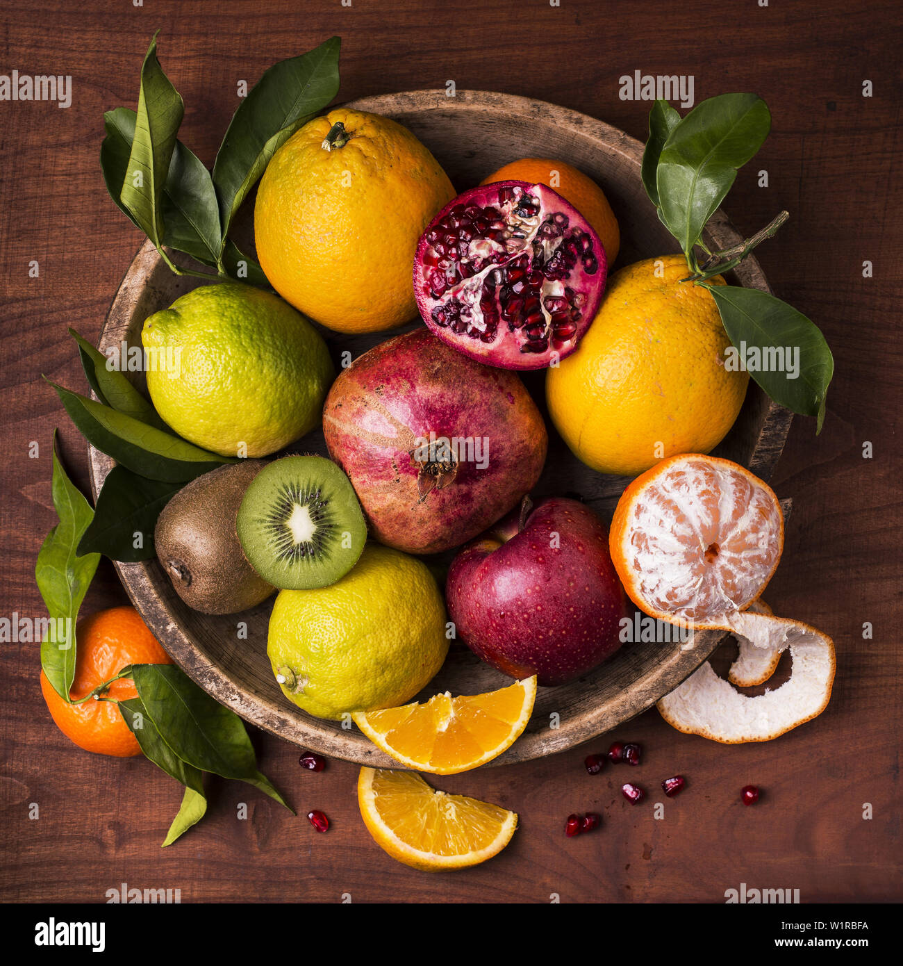 still life with vintage wooden plate full of citrus fruits and fresh ...