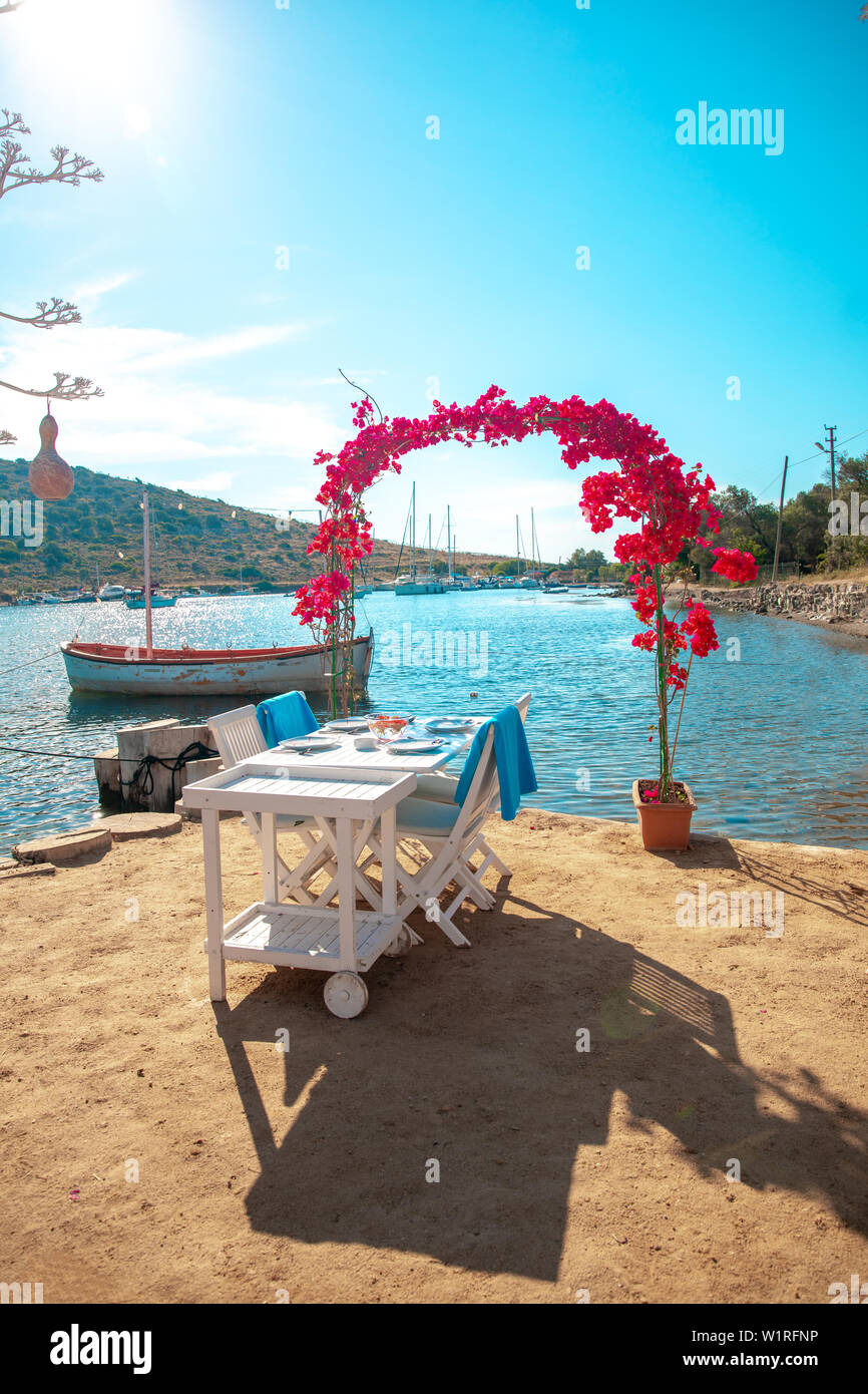 View of fish restaurant, cafe and bougainvillea flowers on beach in ...