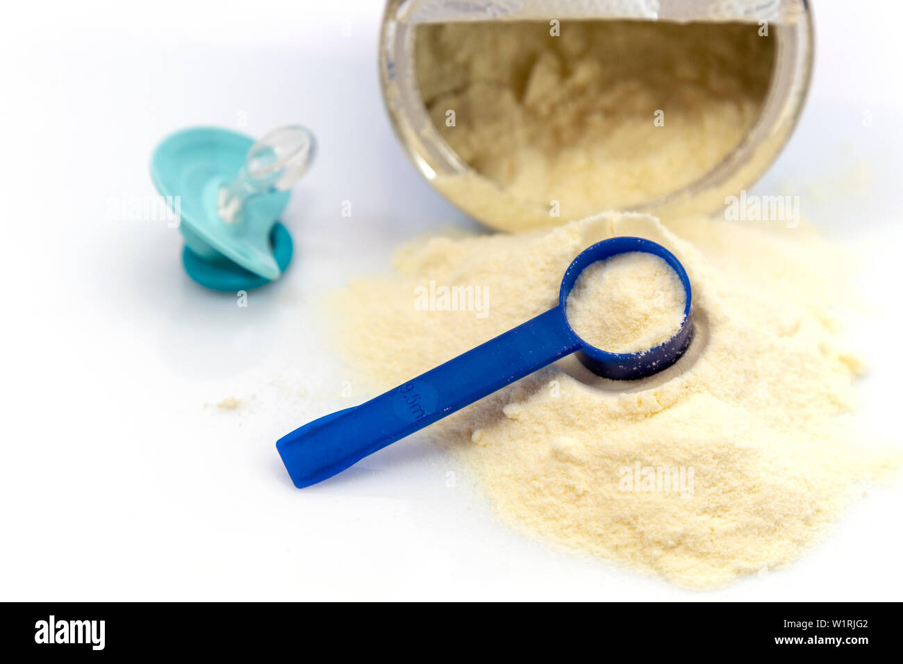Baby formula in can with blue spoon on white background Stock Photo - Alamy