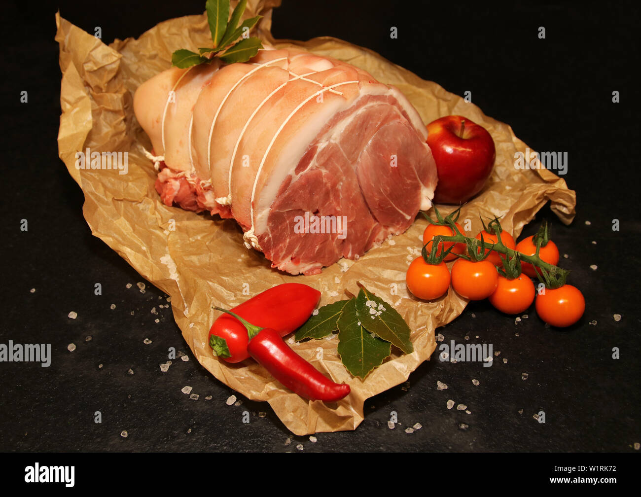 Rolled joint of raw Pork on Black background landscape Stock Photo - Alamy