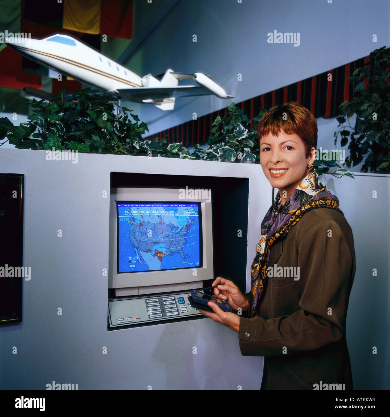 Woman looking at customer while she checks her monitor Stock Photo - Alamy
