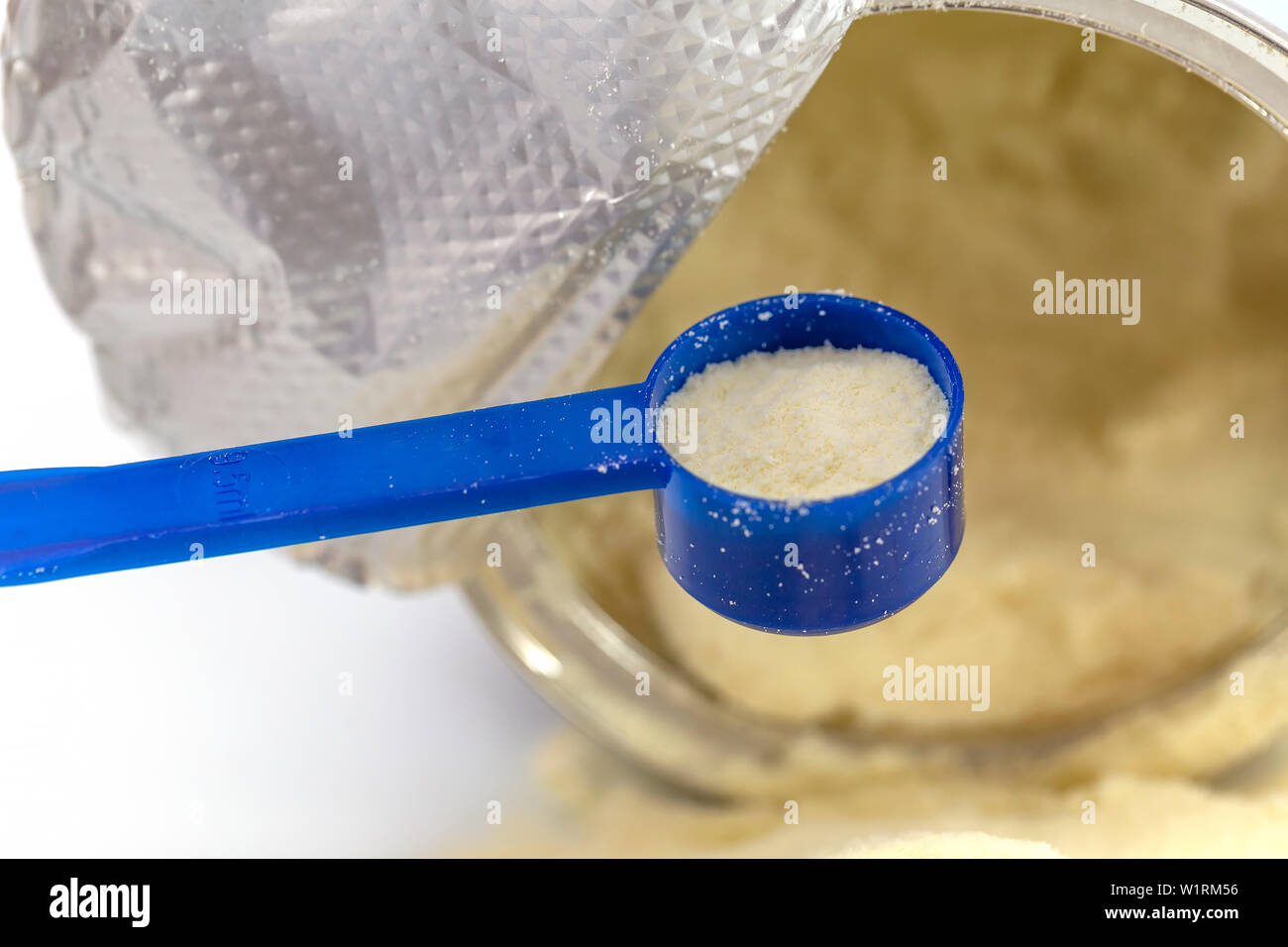 Infant formula in can with blue spoon on white background Stock Photo ...